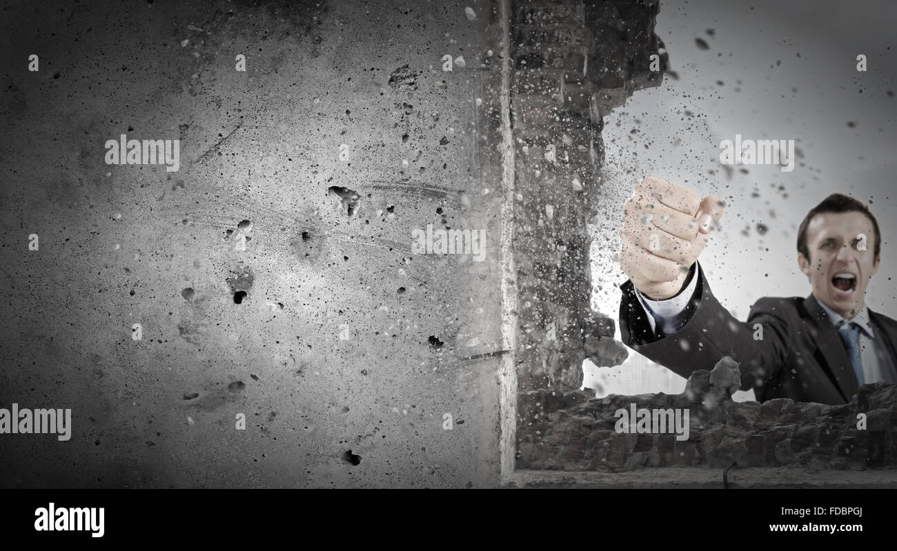 Businessman breaking stone wall with karate punch Stock Photo - Alamy