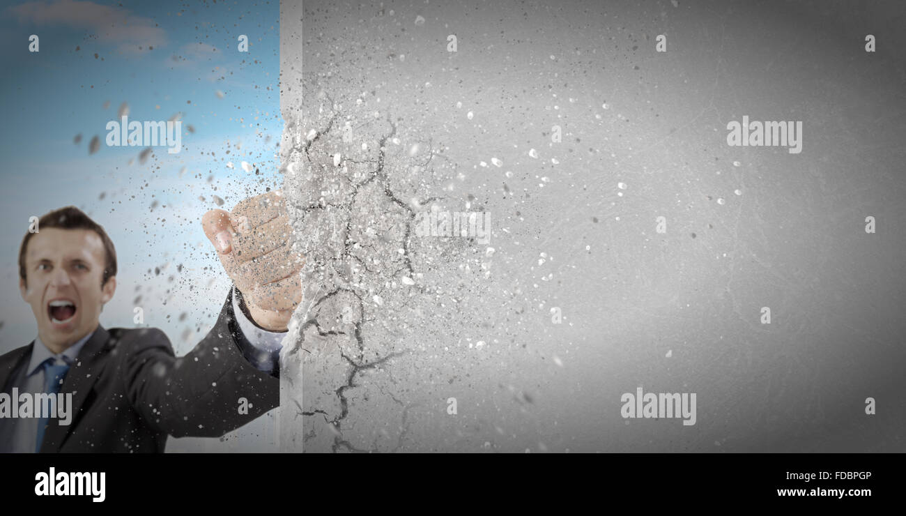 Businessman breaking stone wall with karate punch Stock Photo - Alamy
