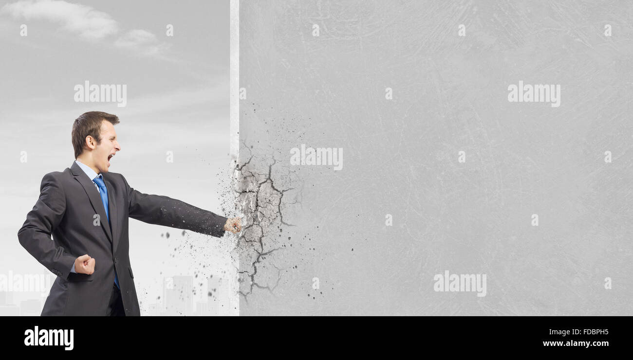 Businessman breaking stone wall with karate punch Stock Photo - Alamy