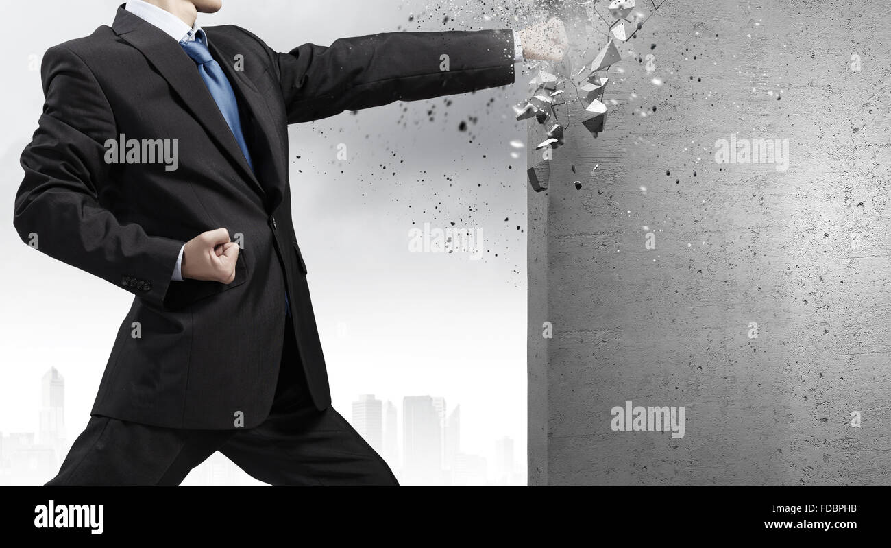 Businessman breaking stone wall with karate punch Stock Photo - Alamy