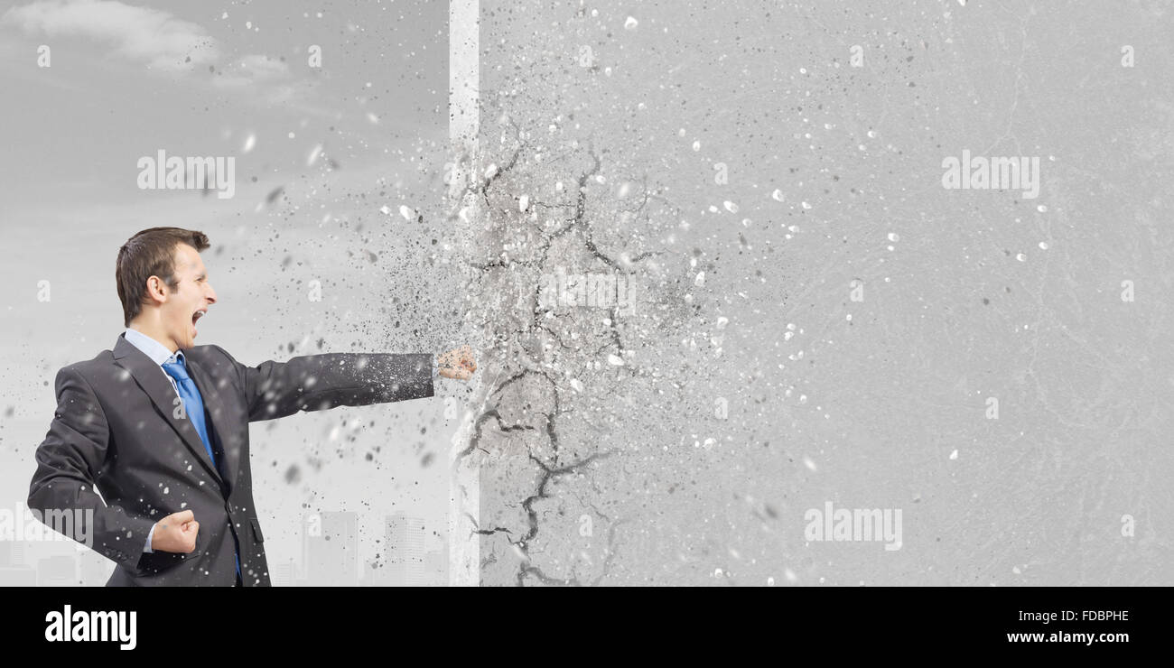 Businessman breaking stone wall with karate punch Stock Photo - Alamy