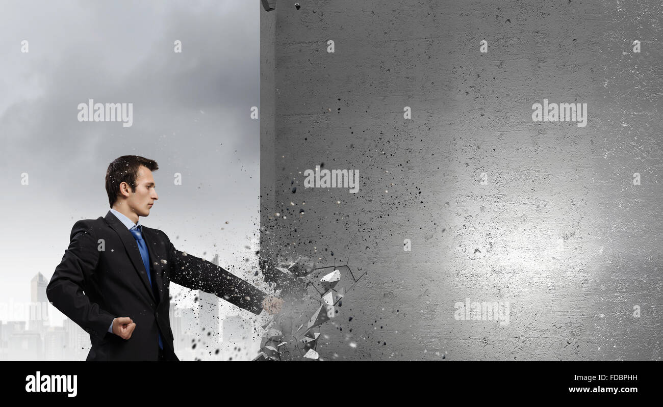 Businessman breaking stone wall with karate punch Stock Photo - Alamy