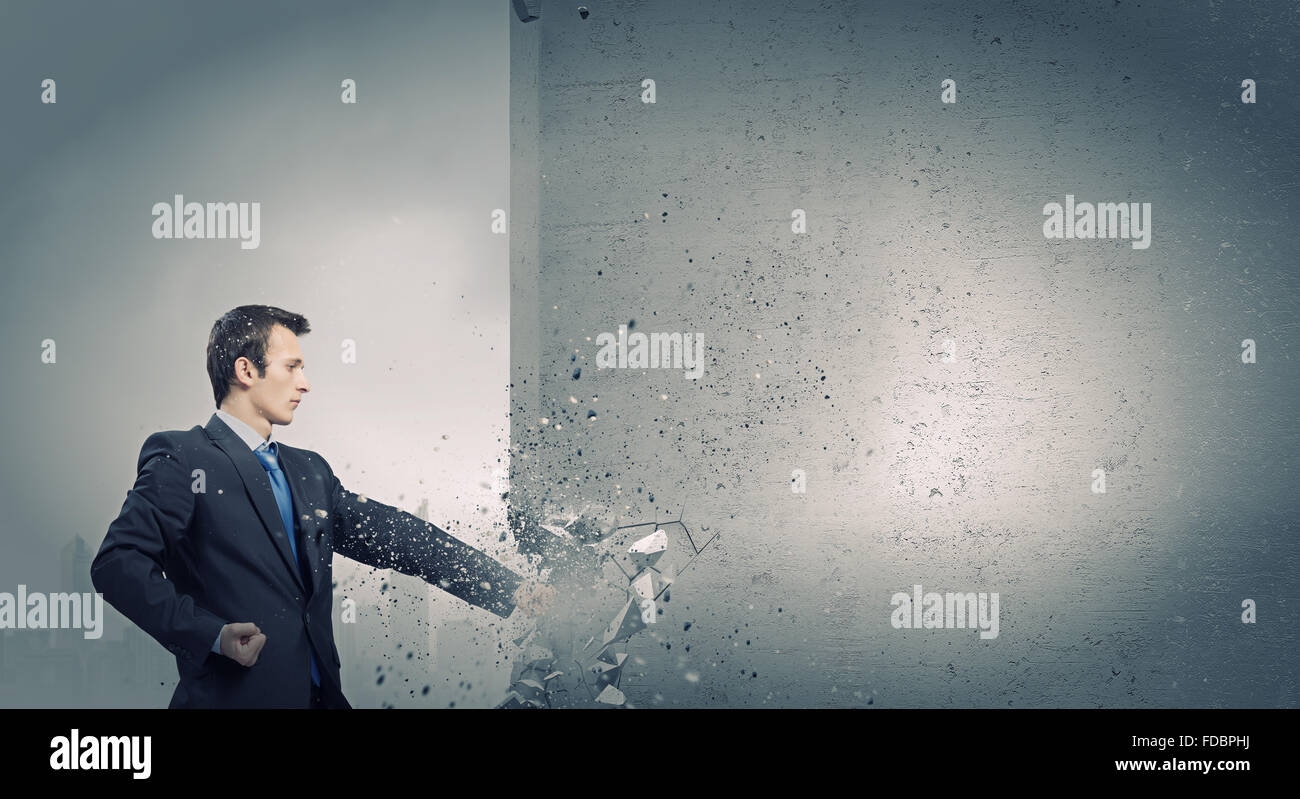 Businessman breaking stone wall with karate punch Stock Photo - Alamy