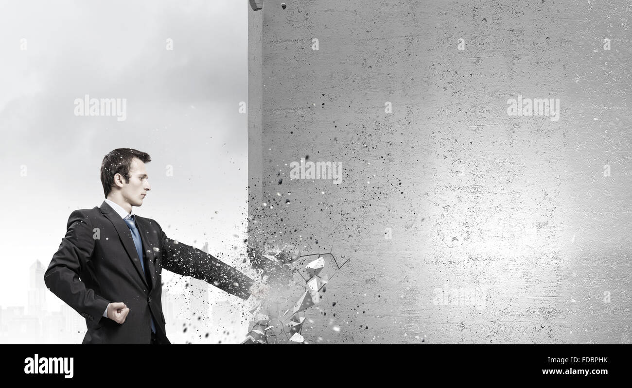 Businessman breaking stone wall with karate punch Stock Photo - Alamy