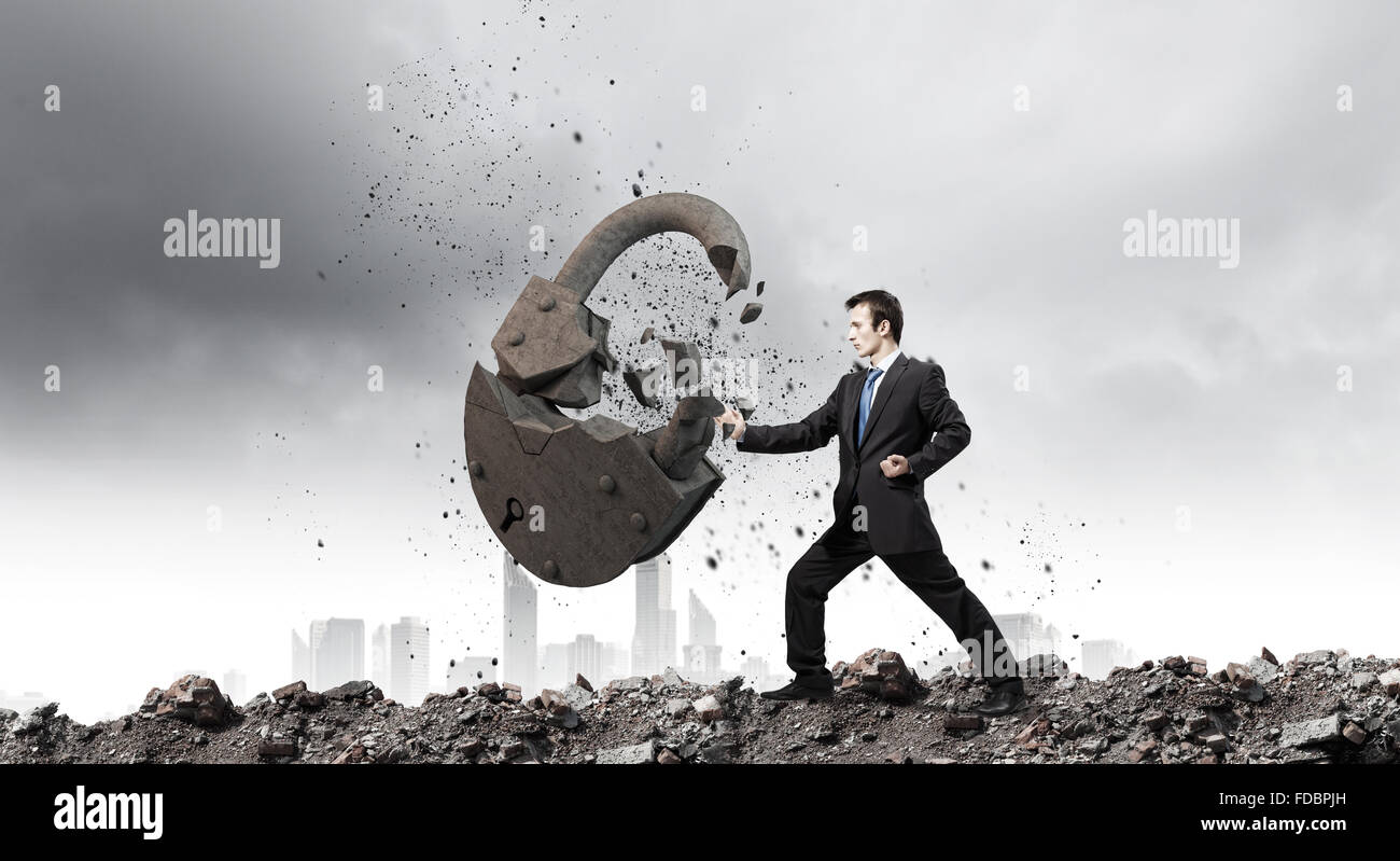 Businessman breaking stone lock with karate kick hi-res stock ...