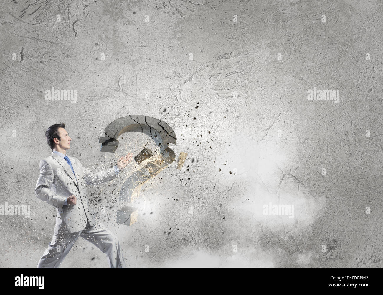 Businessman breaking stone question mark with karate kick Stock Photo ...