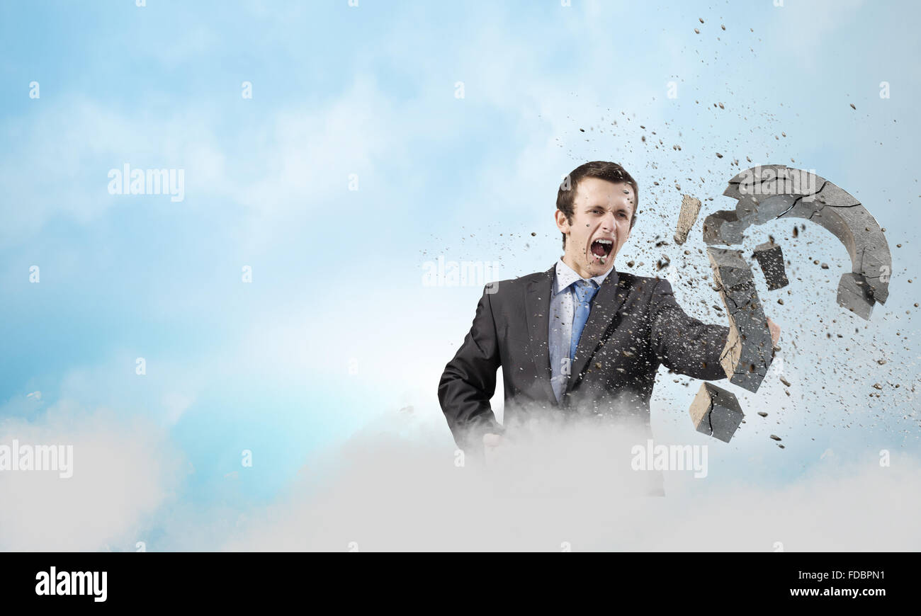 Businessman breaking stone question mark with karate kick Stock Photo ...