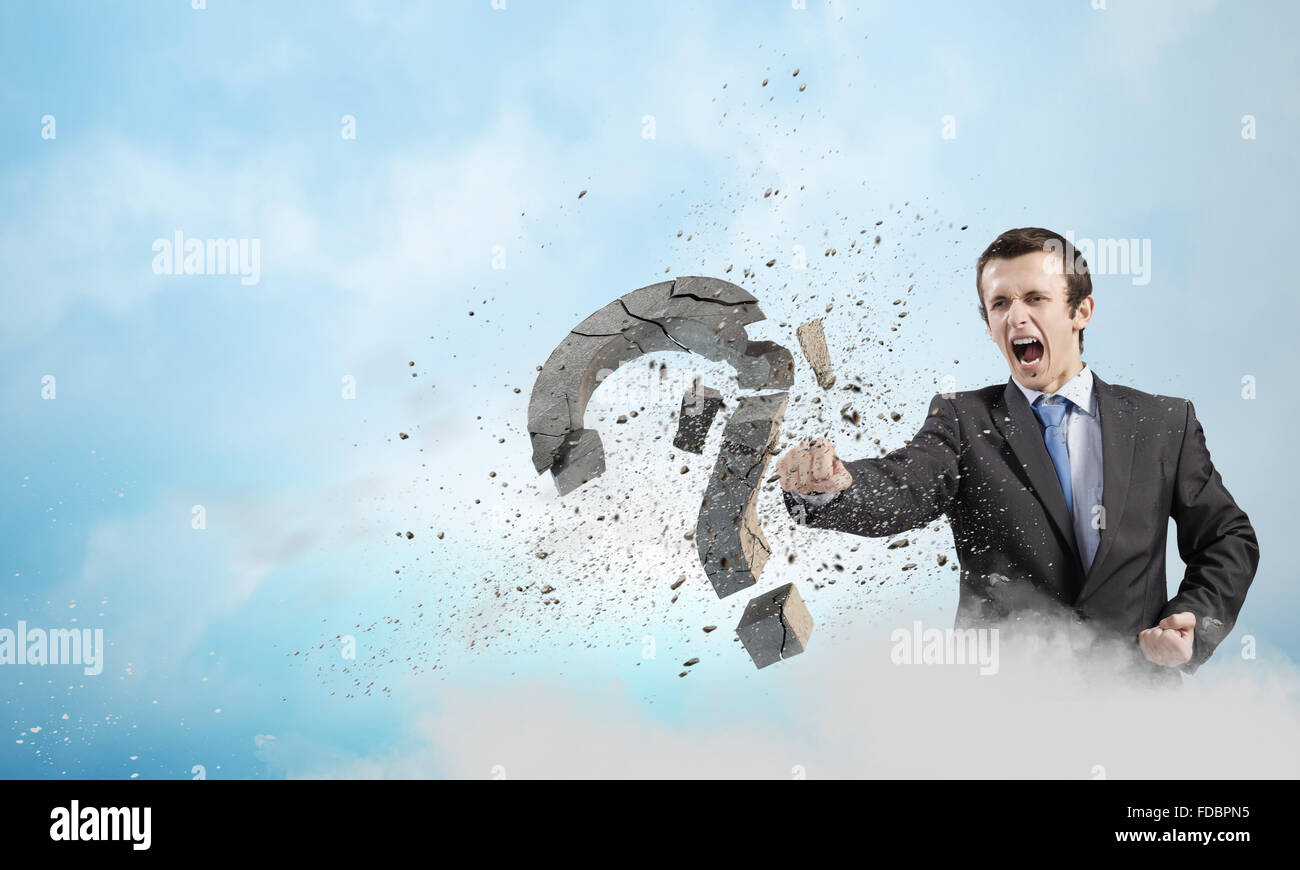 Businessman breaking stone question mark with karate kick Stock Photo ...