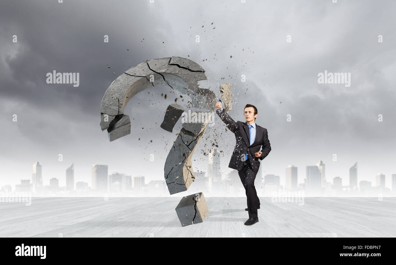 Businessman breaking stone question mark with karate kick Stock Photo ...