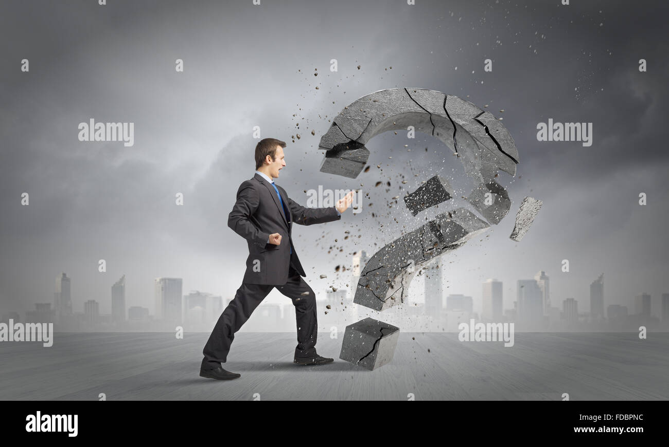 Businessman breaking stone question mark with karate kick Stock Photo ...