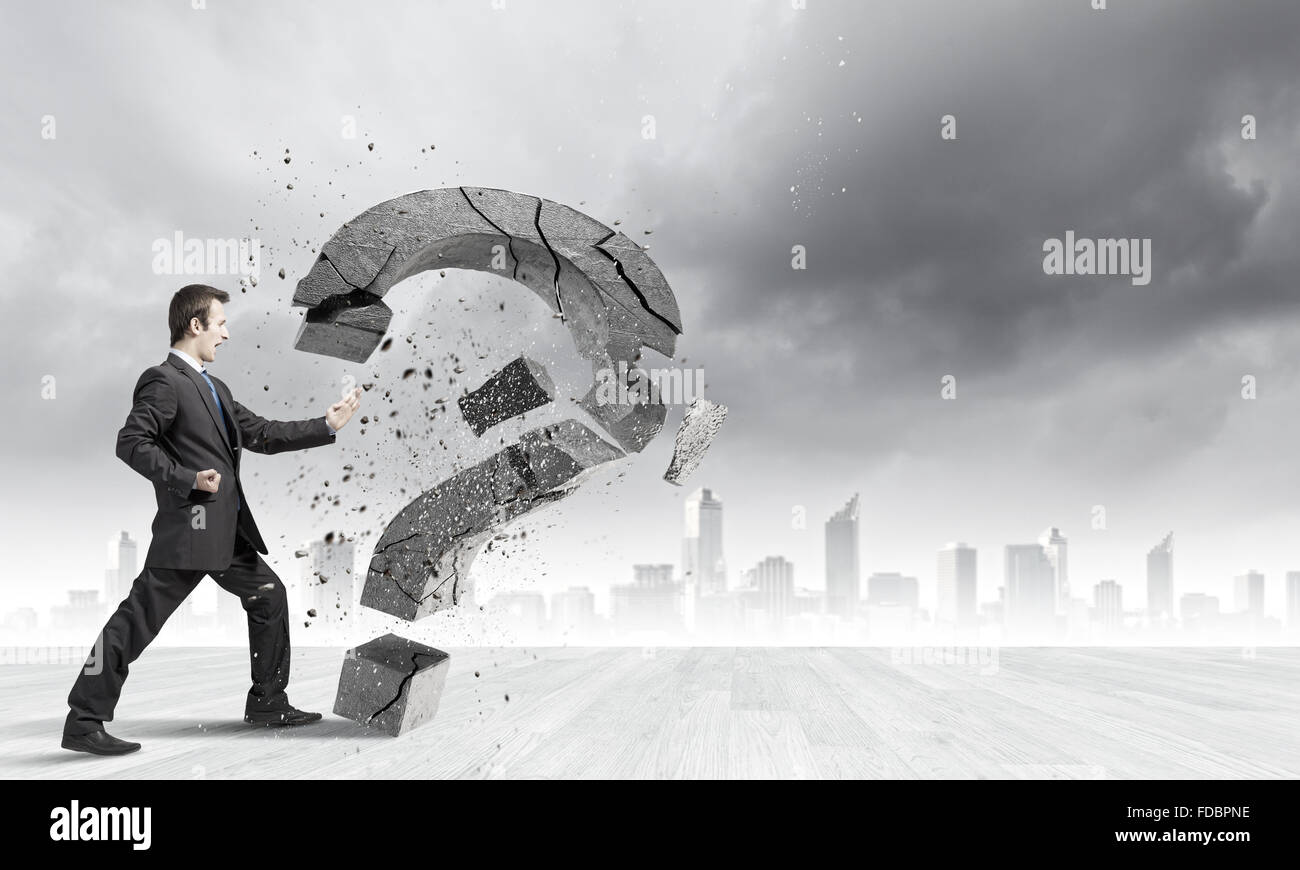 Businessman breaking stone question mark with karate kick Stock Photo ...