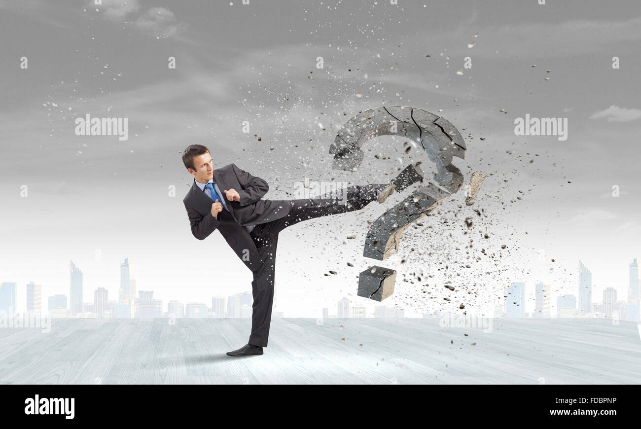 Businessman breaking stone question mark with karate kick Stock Photo ...