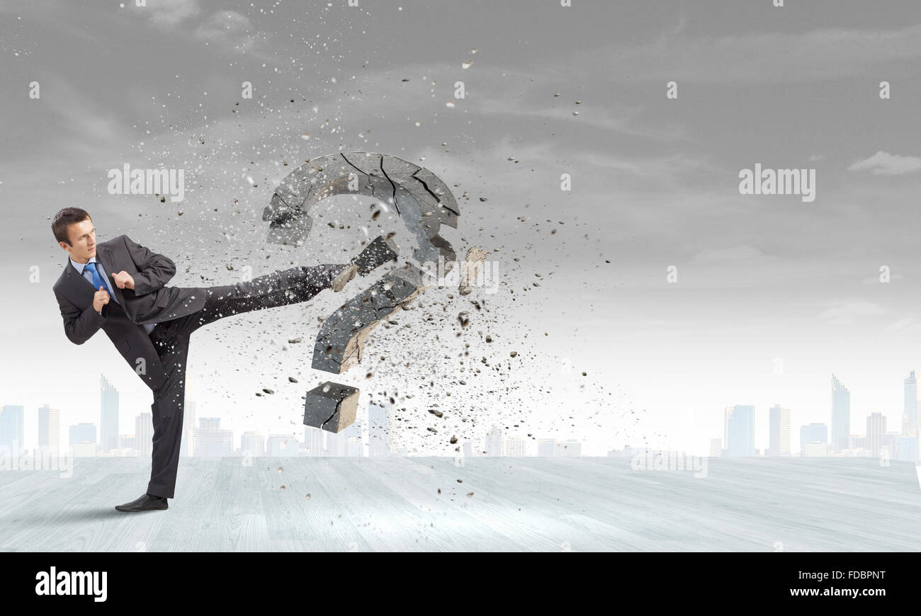 Businessman breaking stone question mark with karate kick Stock Photo ...