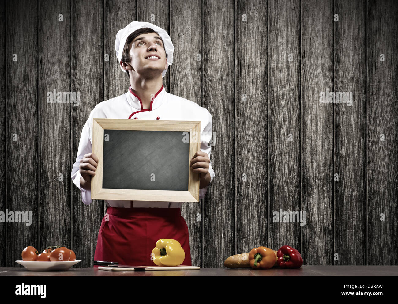 Handsome cook holding blank chalk board. Place for text Stock Photo - Alamy