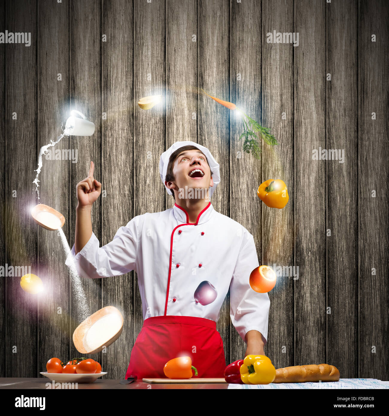 Young cheerful cook and ingredients flying in air Stock Photo - Alamy