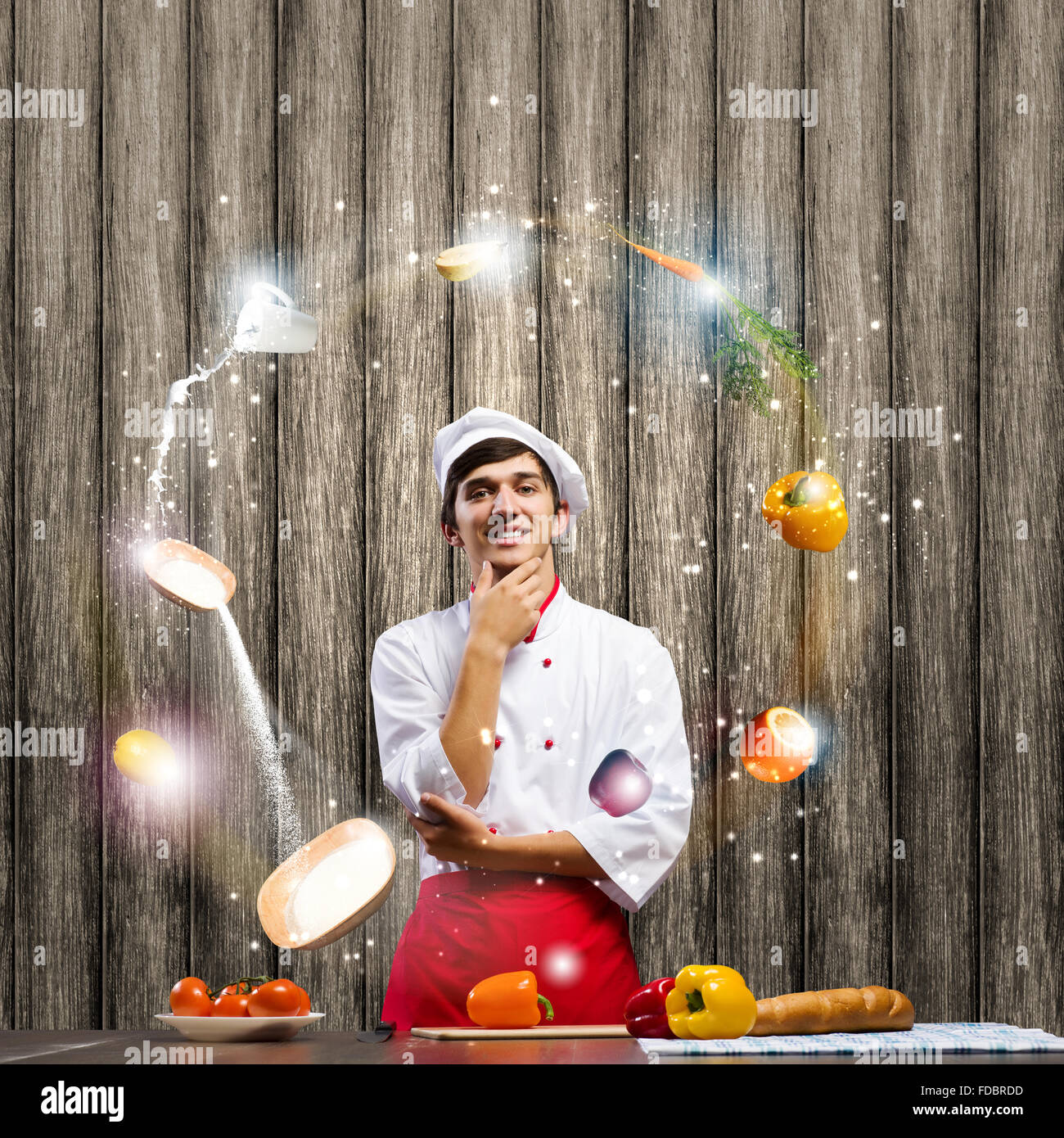 Young cheerful cook and ingredients flying in air Stock Photo - Alamy