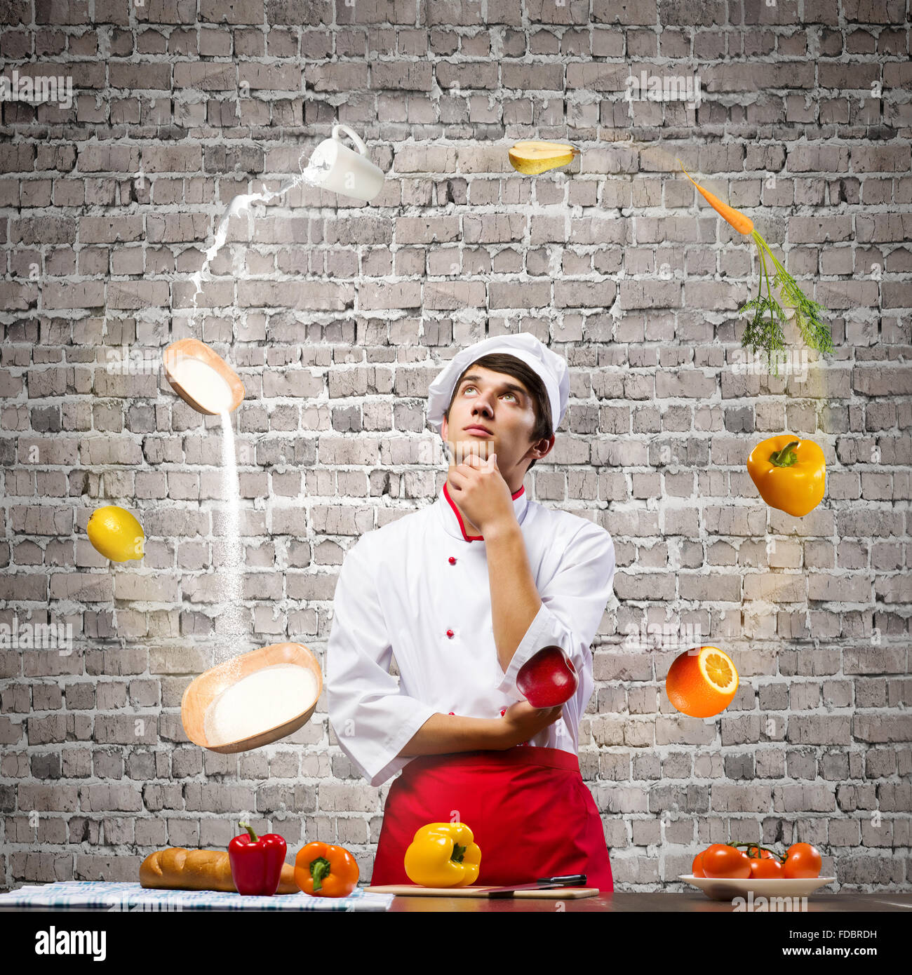 Young thoughtful cook and ingredients flying in air Stock Photo - Alamy