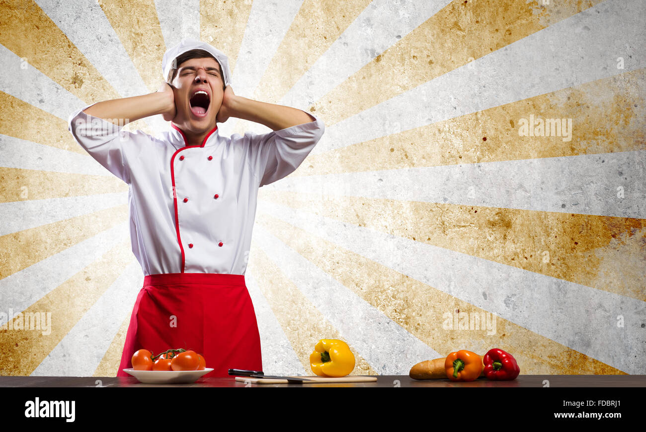 Young screaming cook and vegetables on table Stock Photo - Alamy