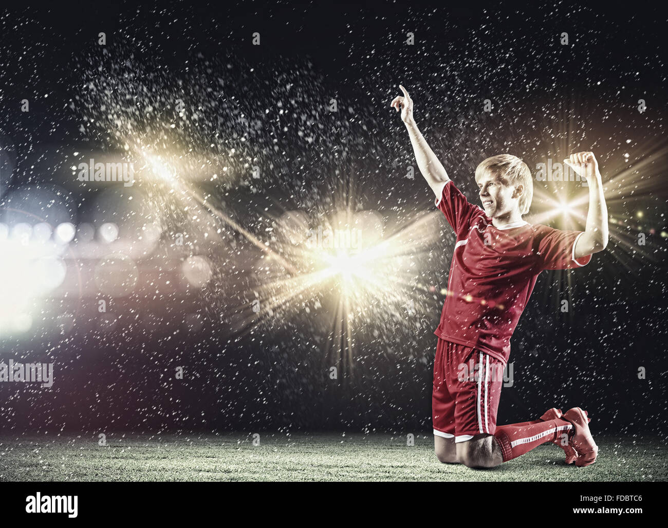 Football player standing on knees and screaming with joy Stock Photo ...