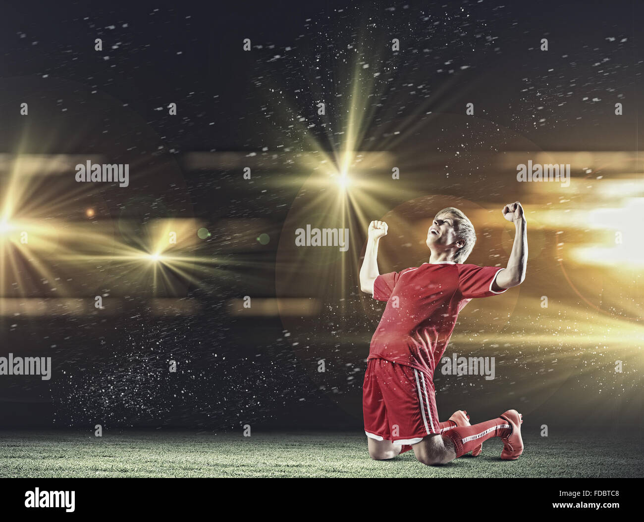 Football player standing on knees and screaming with joy Stock Photo ...