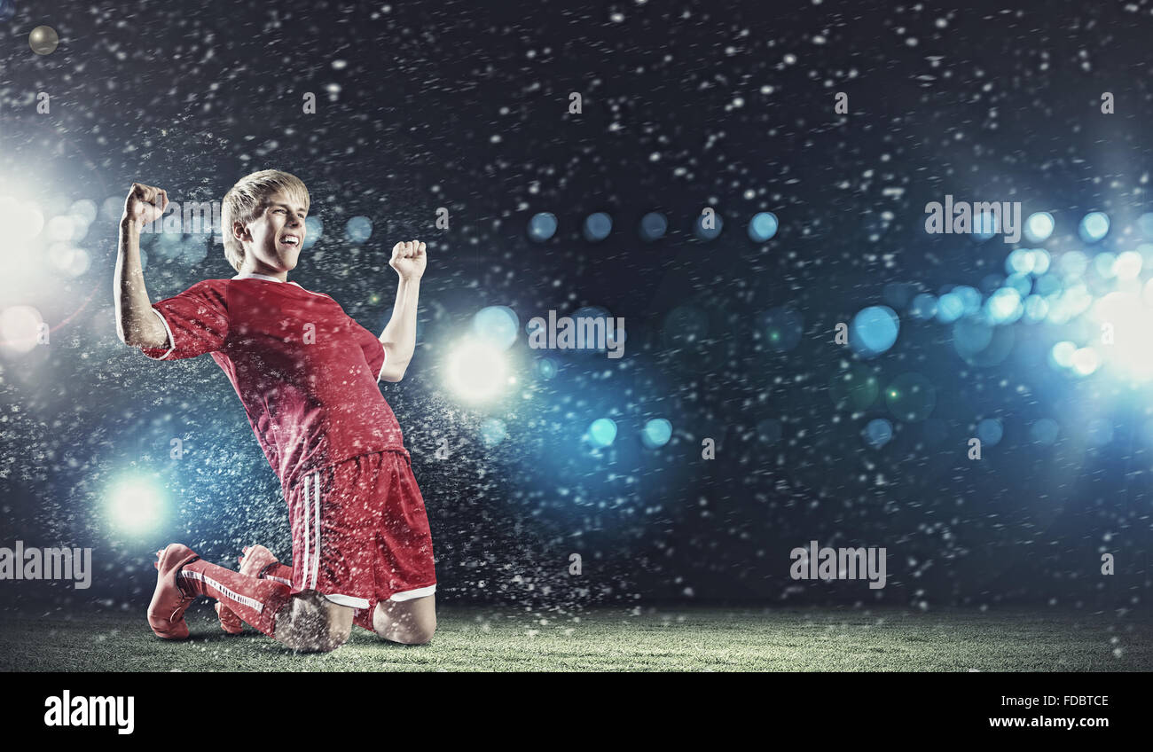 Football player standing on knees and screaming with joy Stock Photo ...
