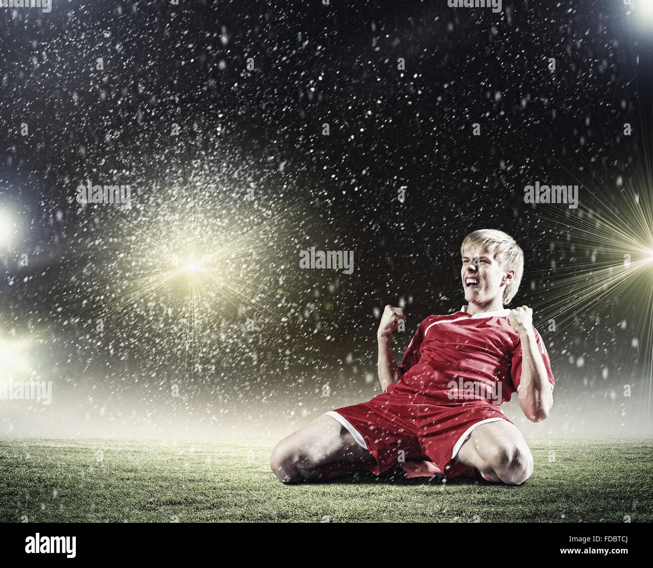 Football player standing on knees and screaming with joy Stock Photo ...