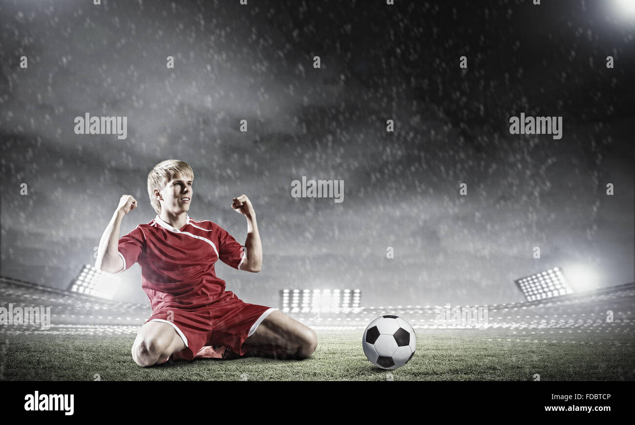 Football player standing on knees and screaming with joy Stock Photo ...
