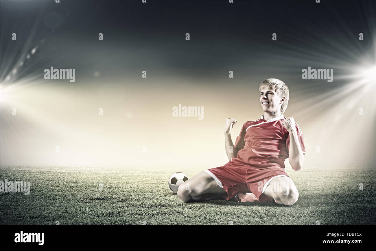 Football player standing on knees and screaming with joy Stock Photo ...