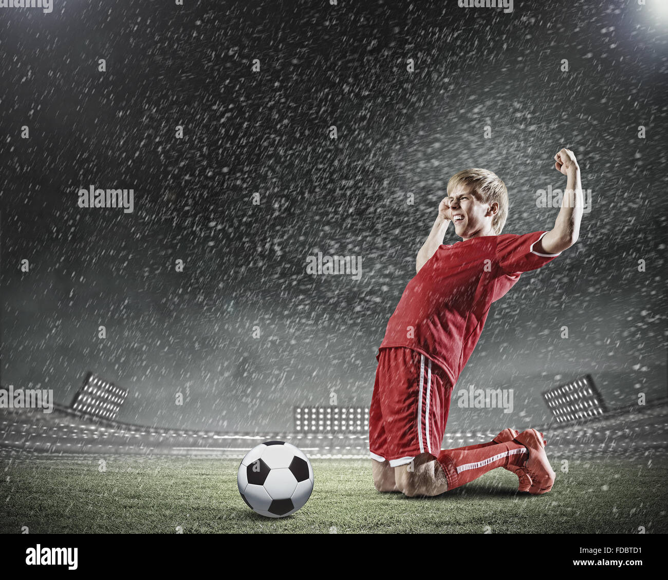 Football player standing on knees and screaming with joy Stock Photo ...
