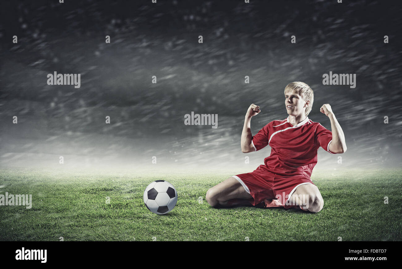 Football player standing on knees and screaming with joy Stock Photo ...