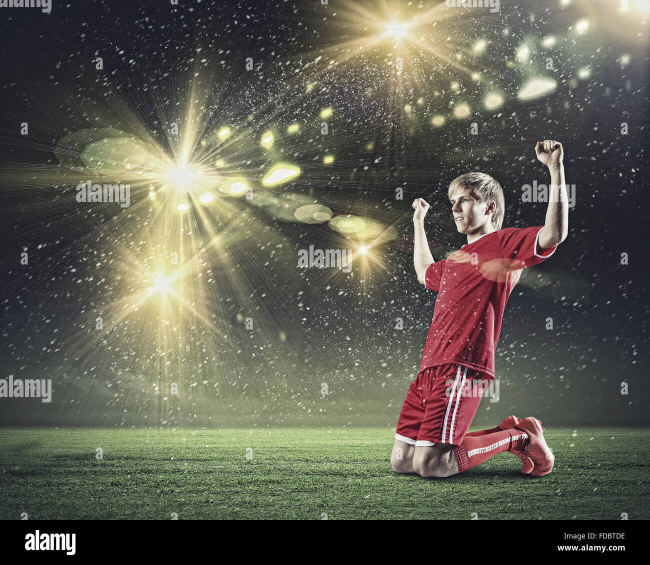 Football player standing on knees and screaming with joy Stock Photo ...