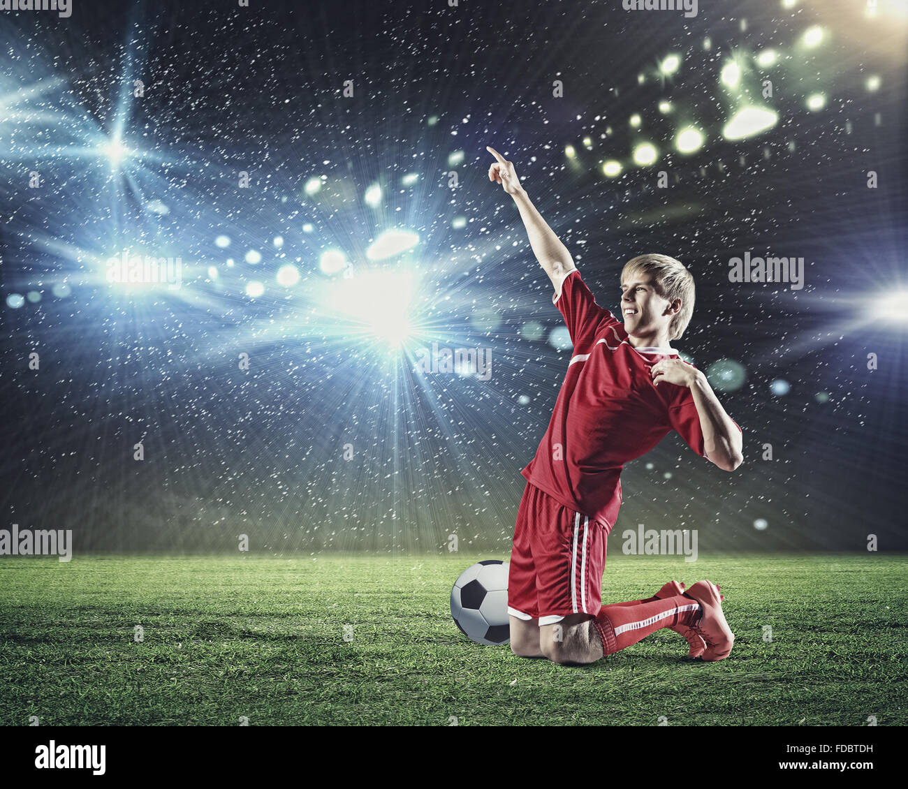 Football player standing on knees and screaming with joy Stock Photo ...