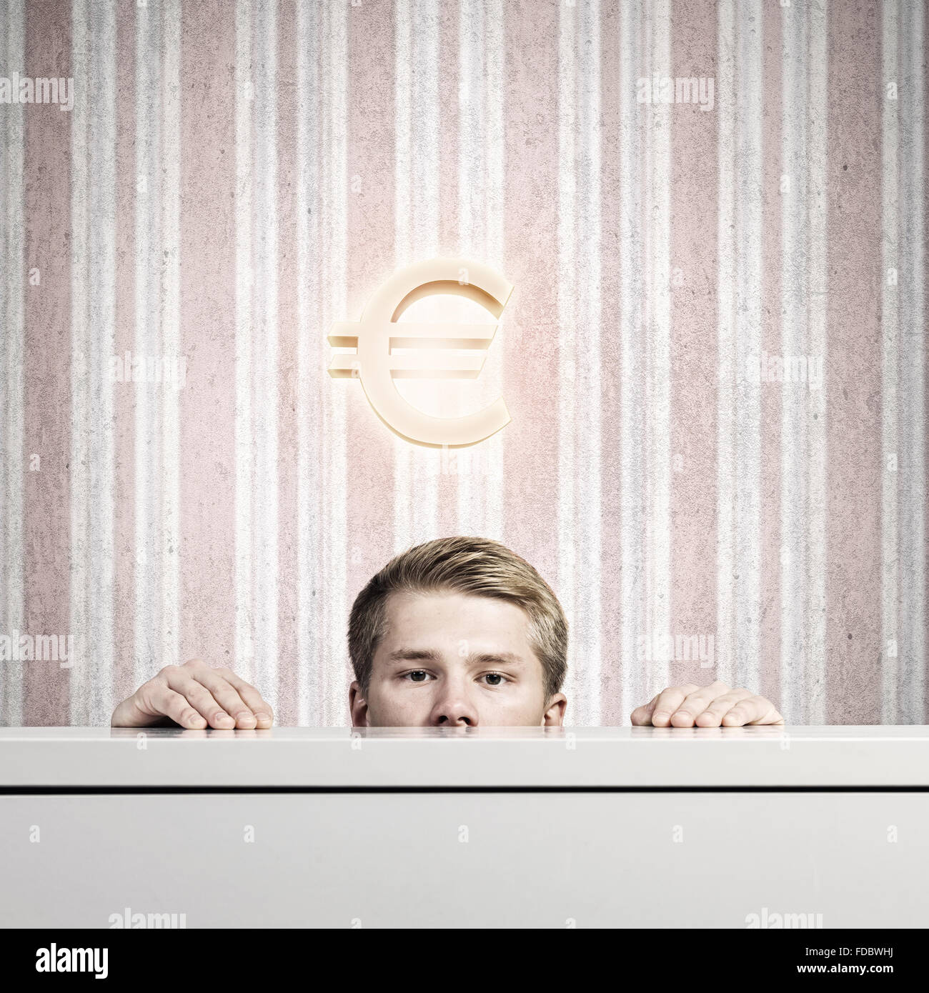 Half of face of young man looking out from under table Stock Photo - Alamy