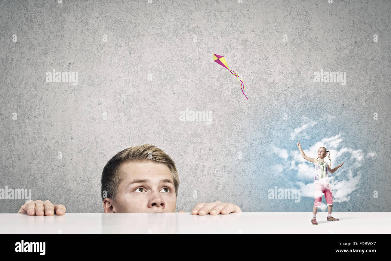Young man looking out from under the table Stock Photo - Alamy