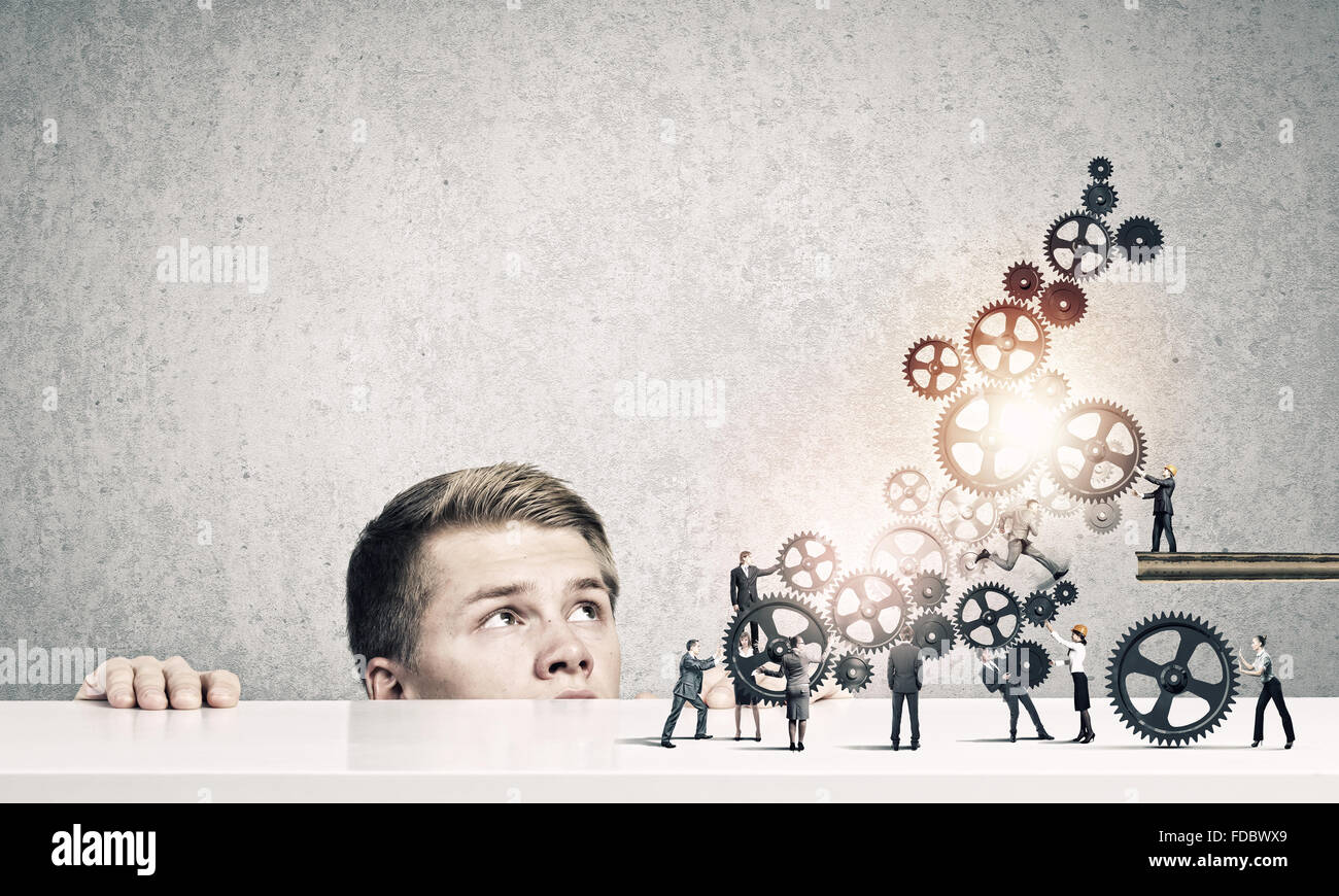 Businessman looking from under the table at businessteam Stock Photo ...