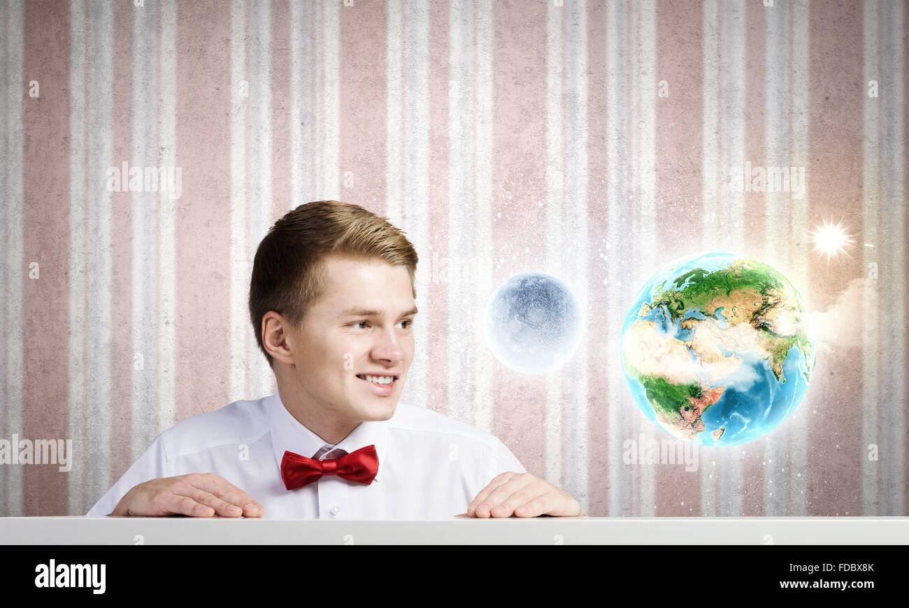 Young man looking at Earth planet. Elements of this image are furnished ...