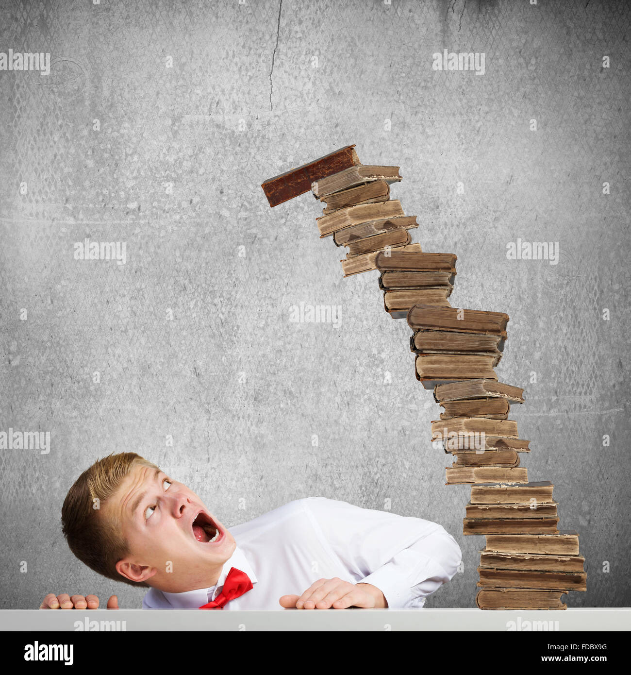 Young handsome businessman and falling pile of books Stock Photo - Alamy