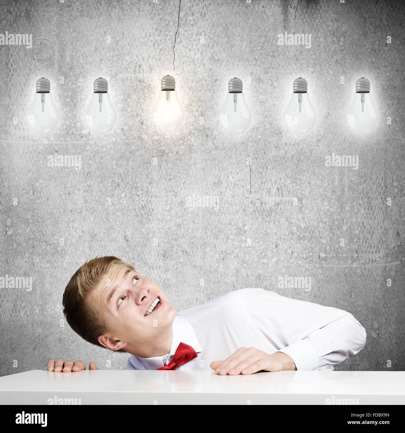 young man looking at light bulbs hanging above Stock Photo - Alamy
