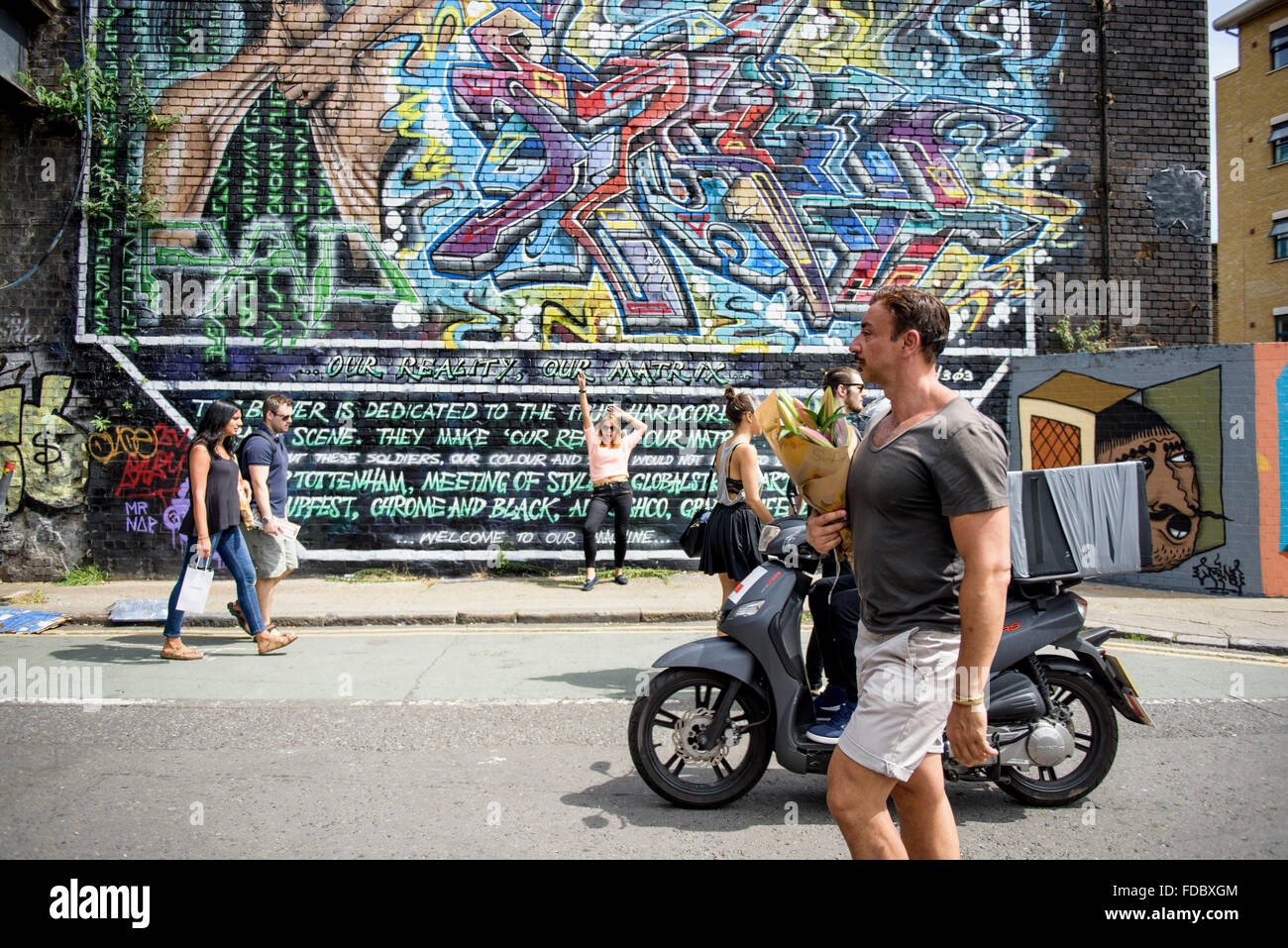 The girl is posing in front of the Matrix graffiti in Shoreditch while ...