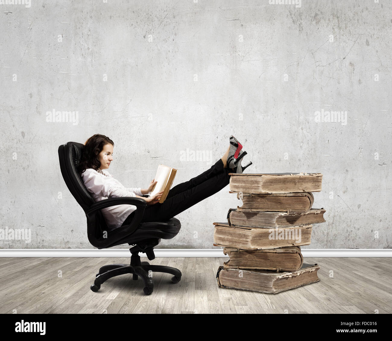 Young businesswoman sitting in chair and reading book Stock Photo - Alamy