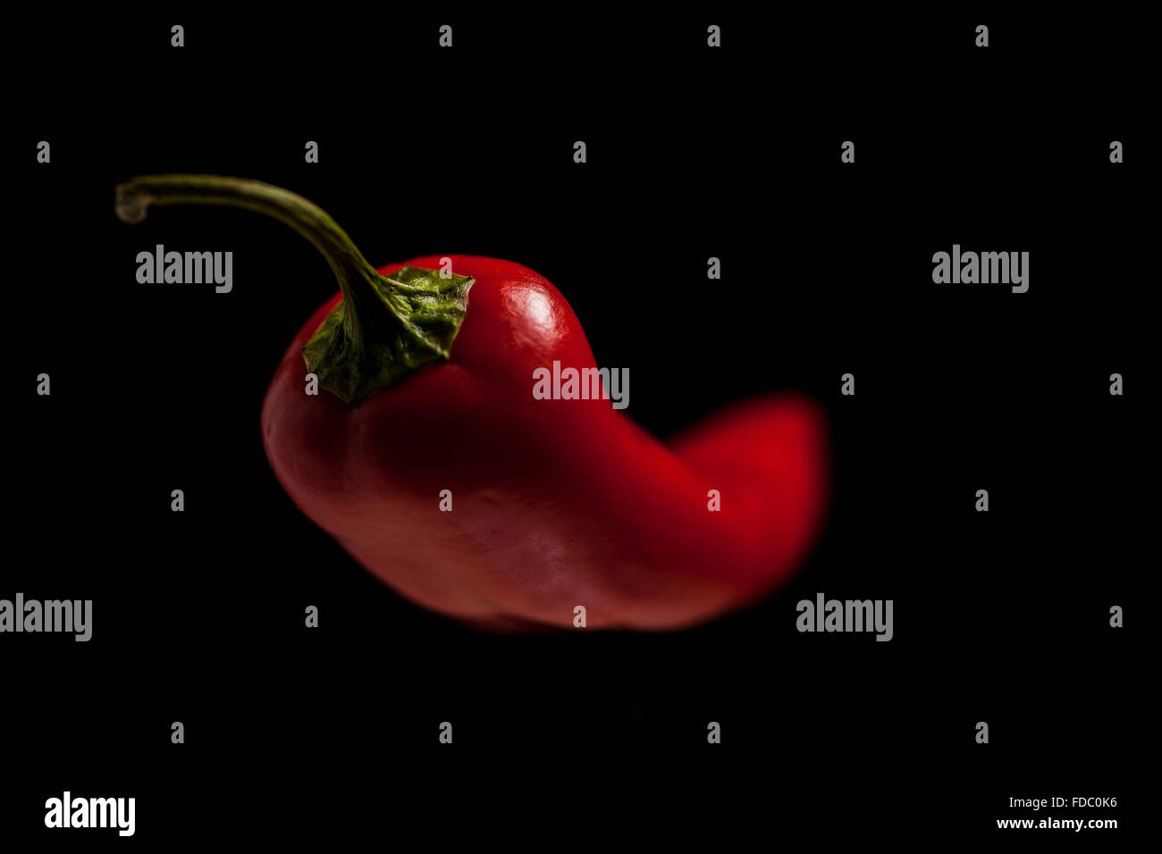 Spicy red chili isolated on a dark background with plenty of copy space ...