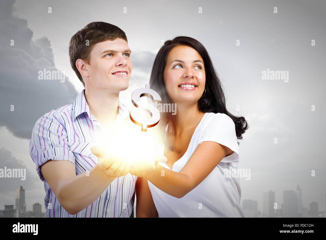 Young happy couple holding dollar sign in palms Stock Photo - Alamy