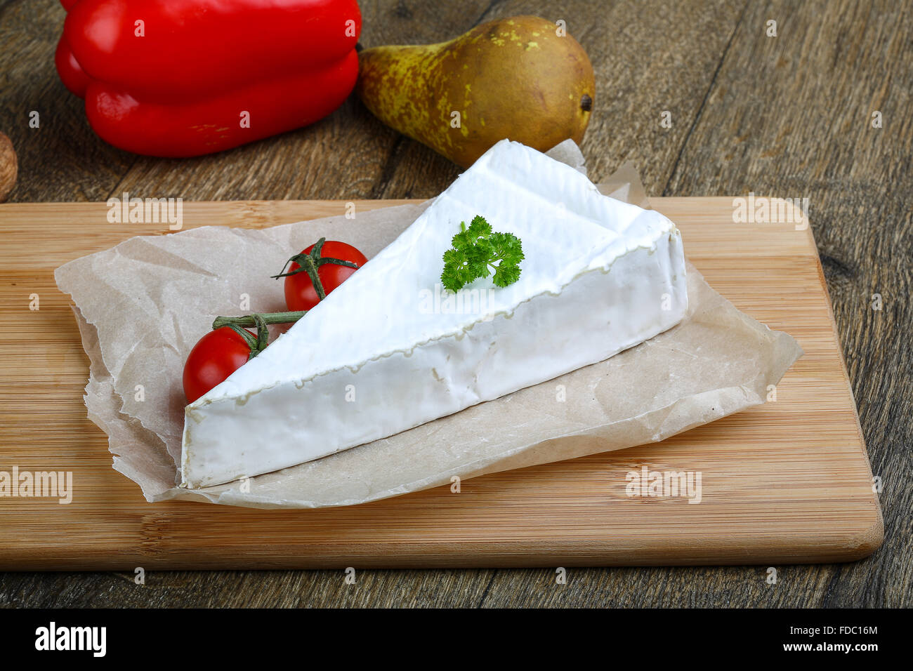 Brie cheese triangle with tomato and parsley Stock Photo - Alamy