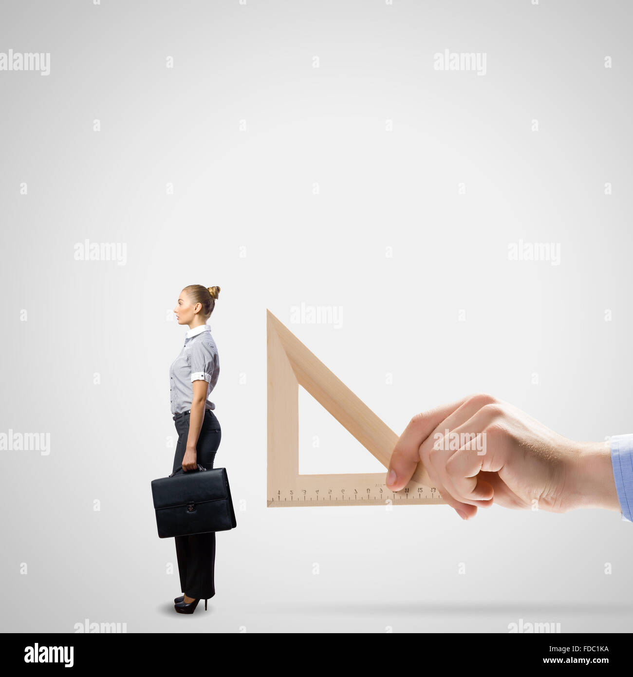Businessman measuring miniature of business lady with ruler Stock Photo ...