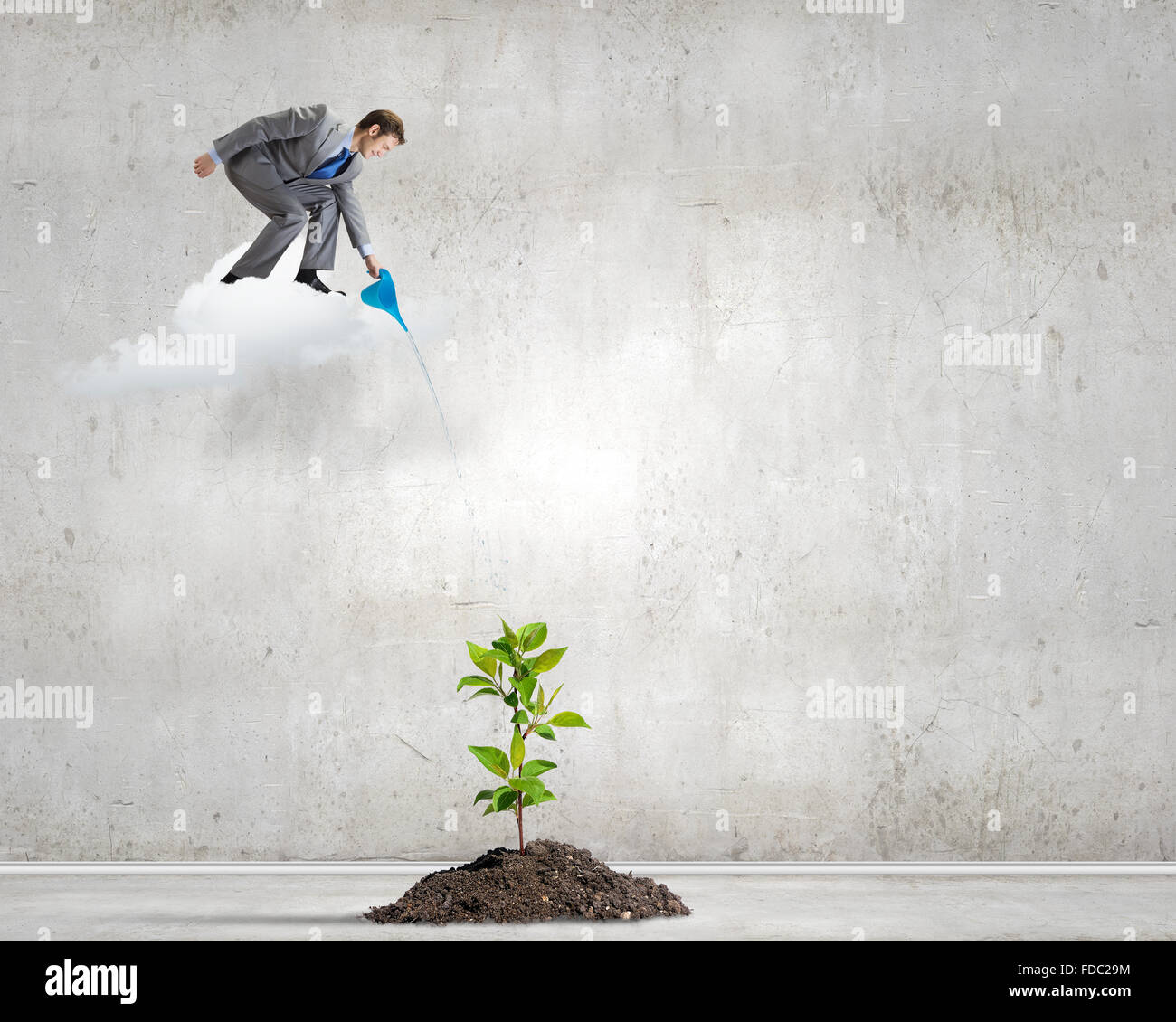 Young businessman standing on cloud and watering sprout Stock Photo - Alamy