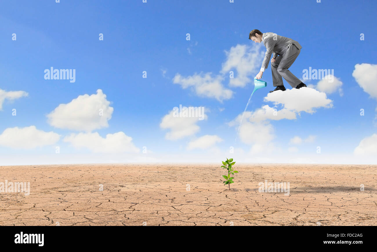 Young businessman standing on cloud and watering sprout Stock Photo - Alamy