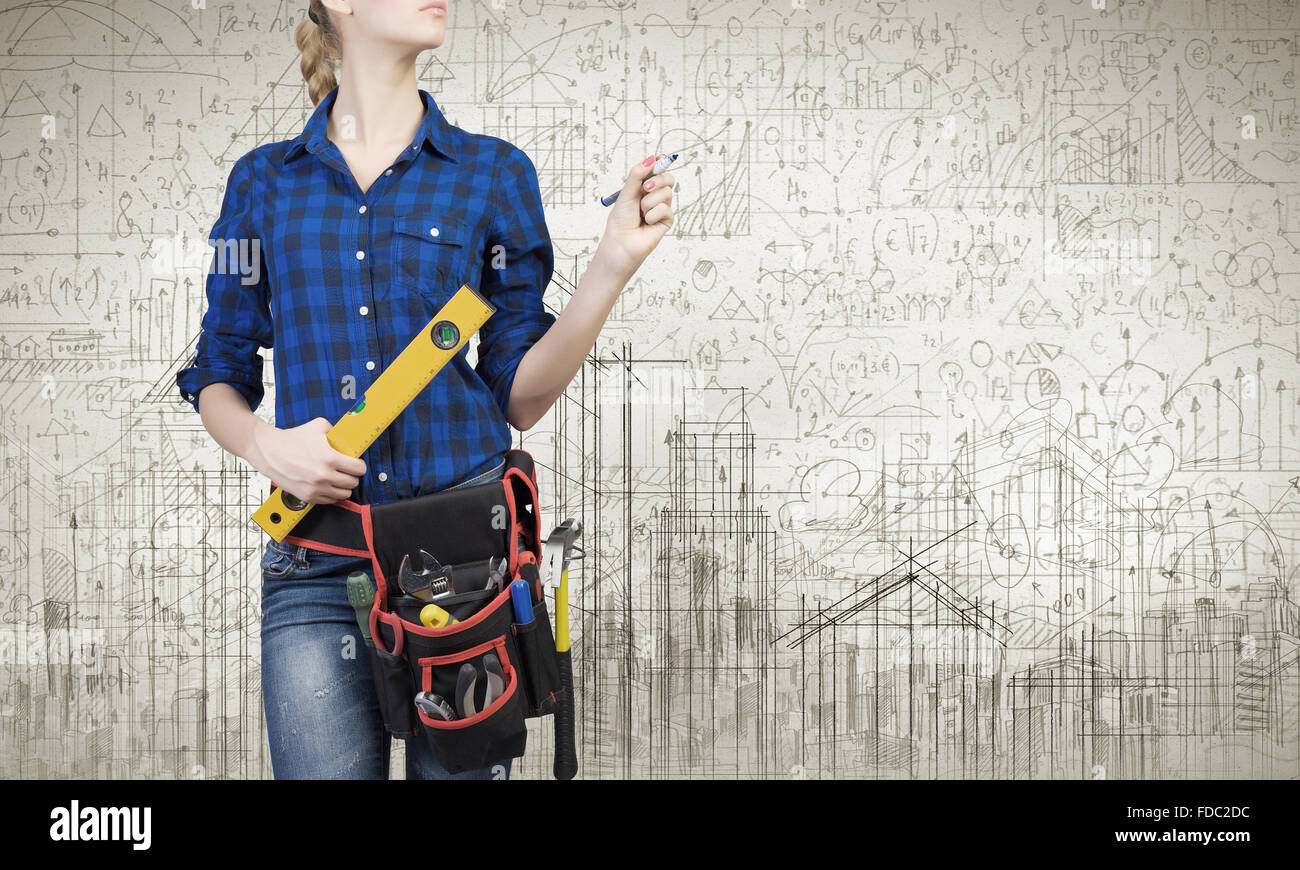 Young woman mechanic with ruler in hand against city background Stock ...