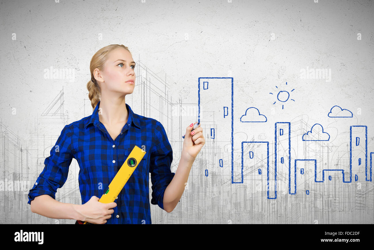 Young woman mechanic with ruler in hand against city background Stock ...
