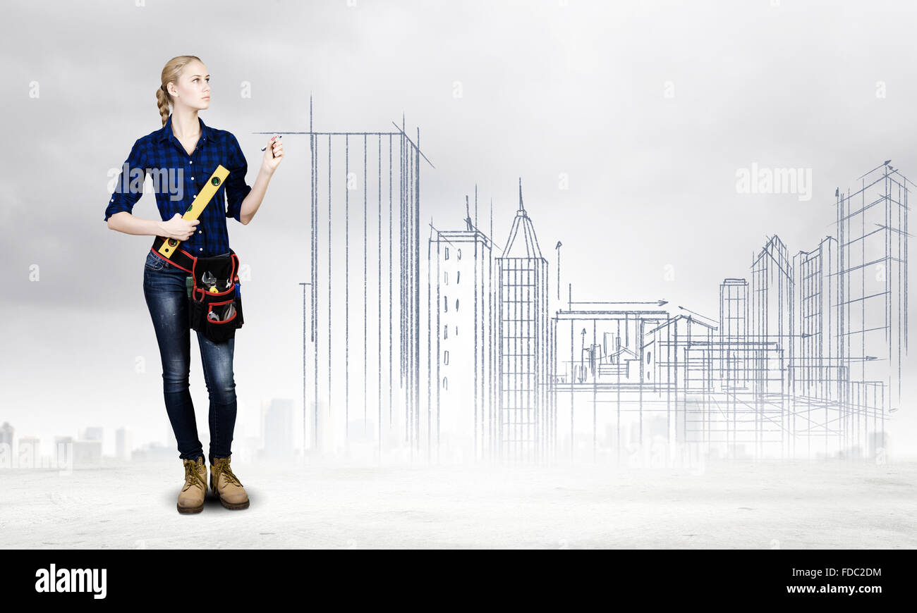 Young woman mechanic with ruler in hand against city background Stock ...