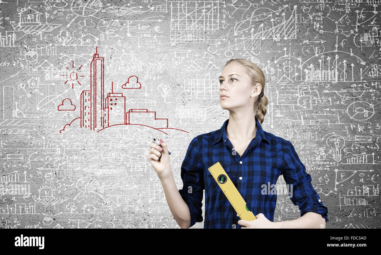 Young woman mechanic with ruler in hand against city background Stock ...
